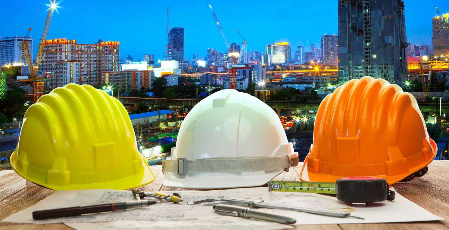 engineer working table with hard hat plan and writing tool against ...